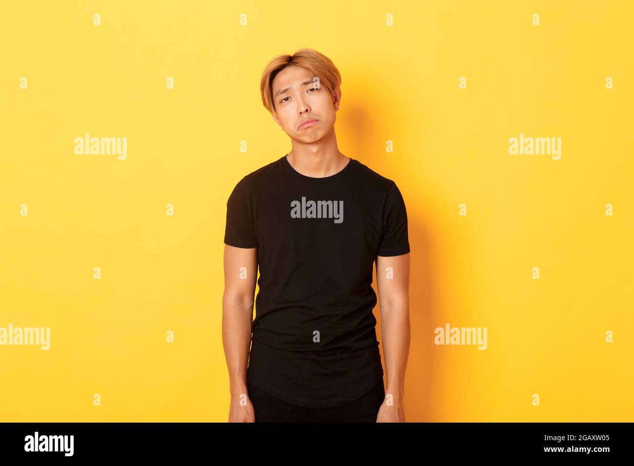 Portrait of exhausted and sad asian guy looking sad, standing drained ...