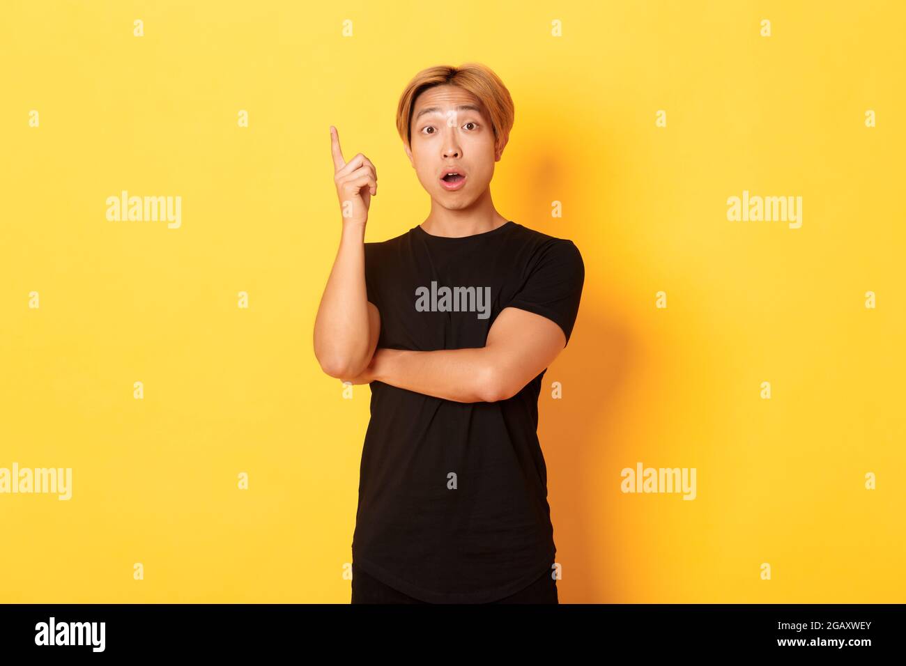 Portrait of thoughtful handsome asian man raising finger, suggesting ...