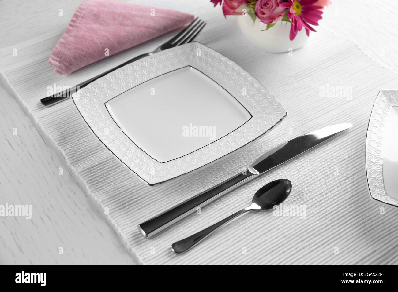 Table setting with plates and cutlery on white background Stock Photo ...