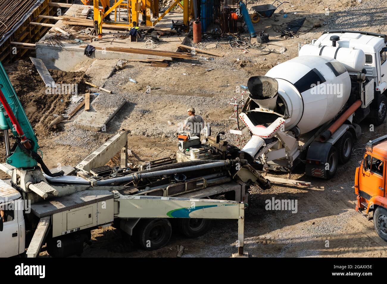 concreting work: construction site worker during concrete pouring into ...