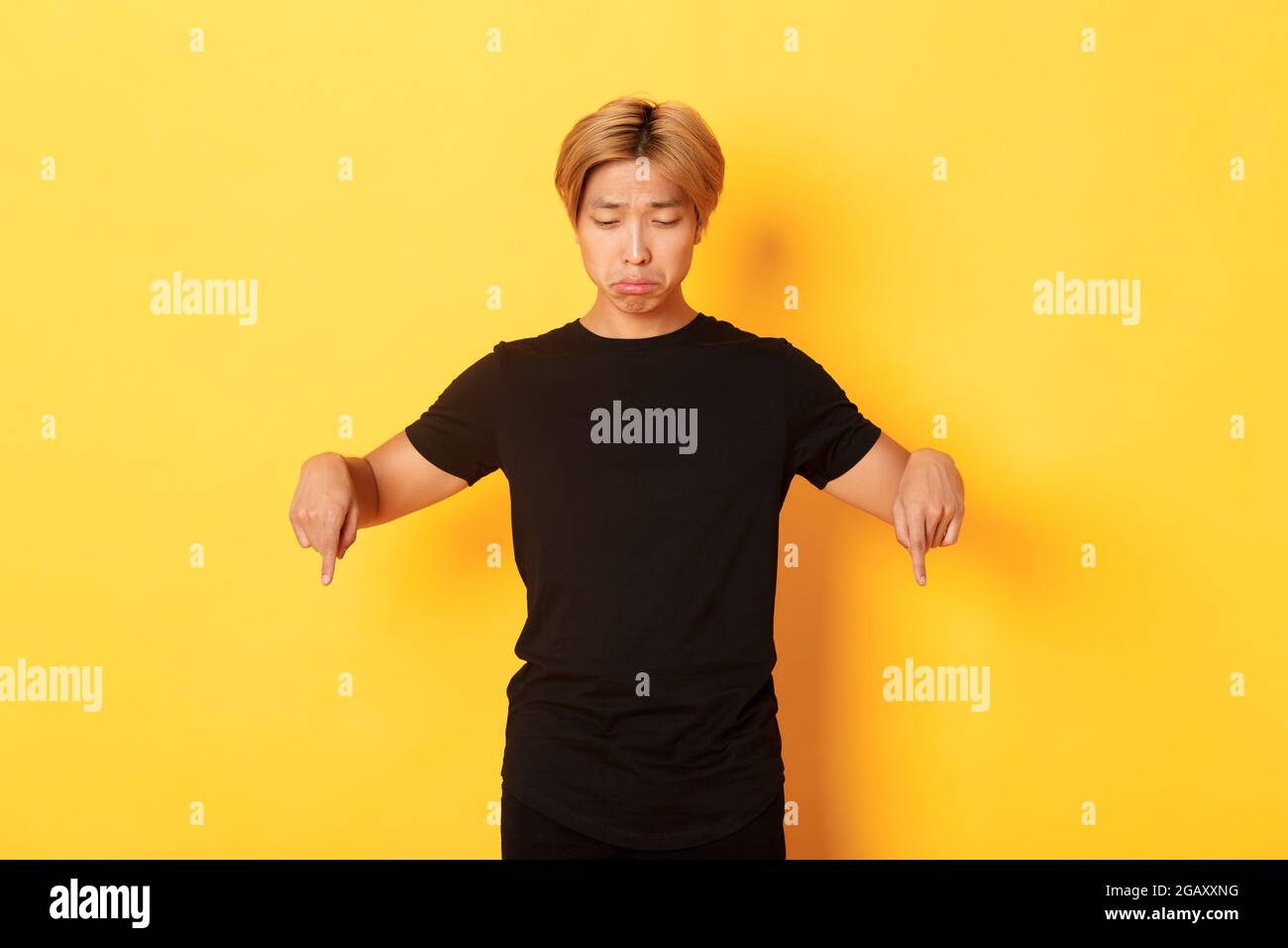 Portrait of gloomy and upset asian man sulking with regret, pointing ...