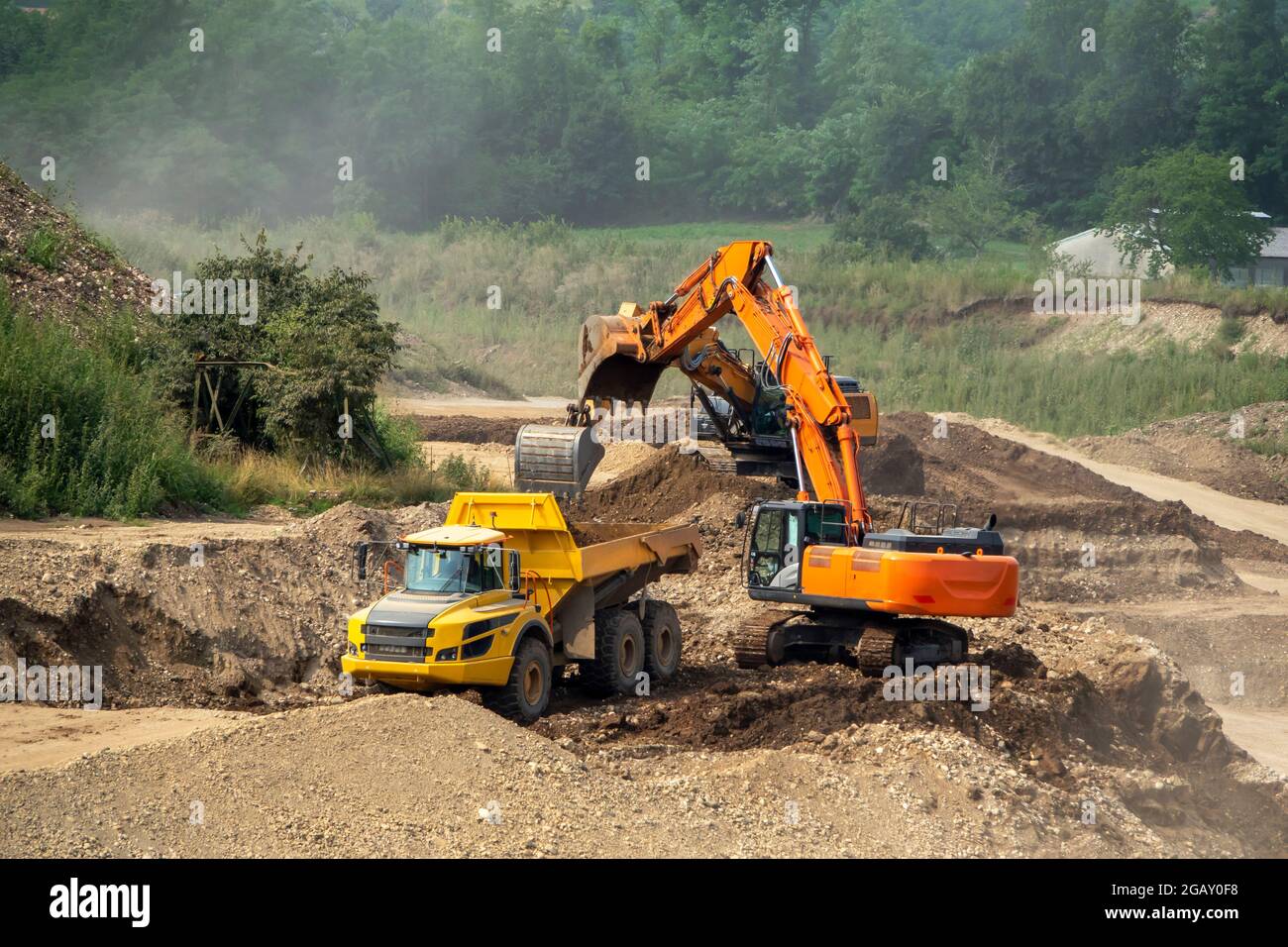 Dump truck and excavator at work. Extraction. The excavator loads the ...