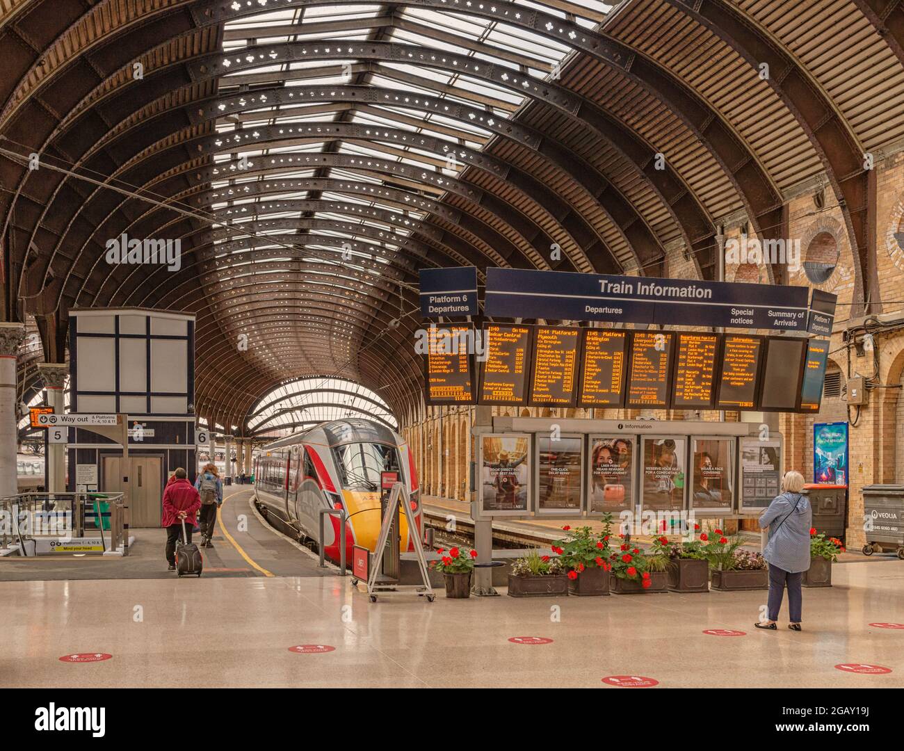 A station concourse with a station electronic notice board and a train ...