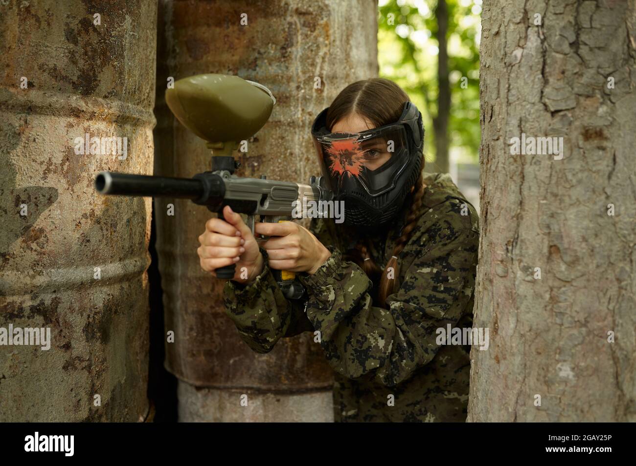 Female paintball player on playground in forest Stock Photo - Alamy