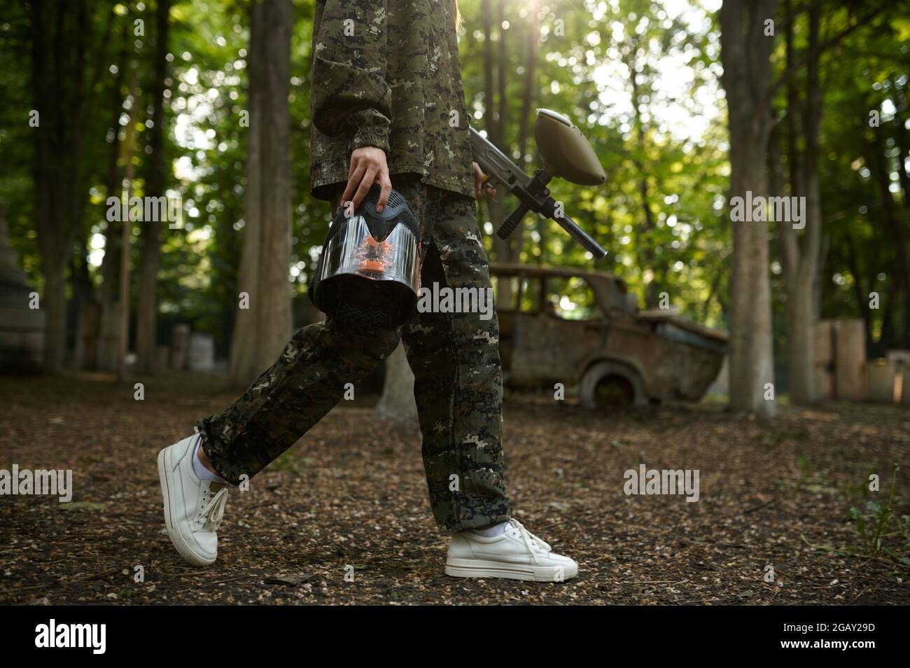 Female paintball player holds gun and mask Stock Photo - Alamy