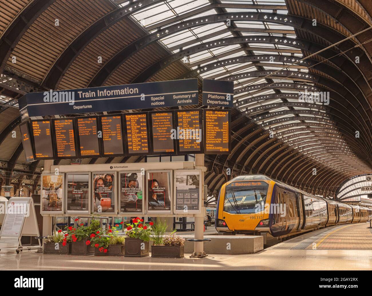A station concourse with a station electronic notice board with notices ...