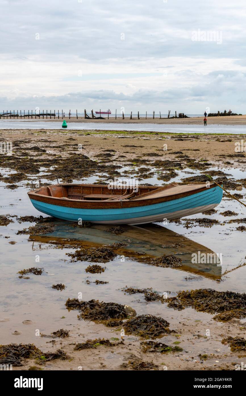 small blue painted rowing boat on the beach at st helens duver ...