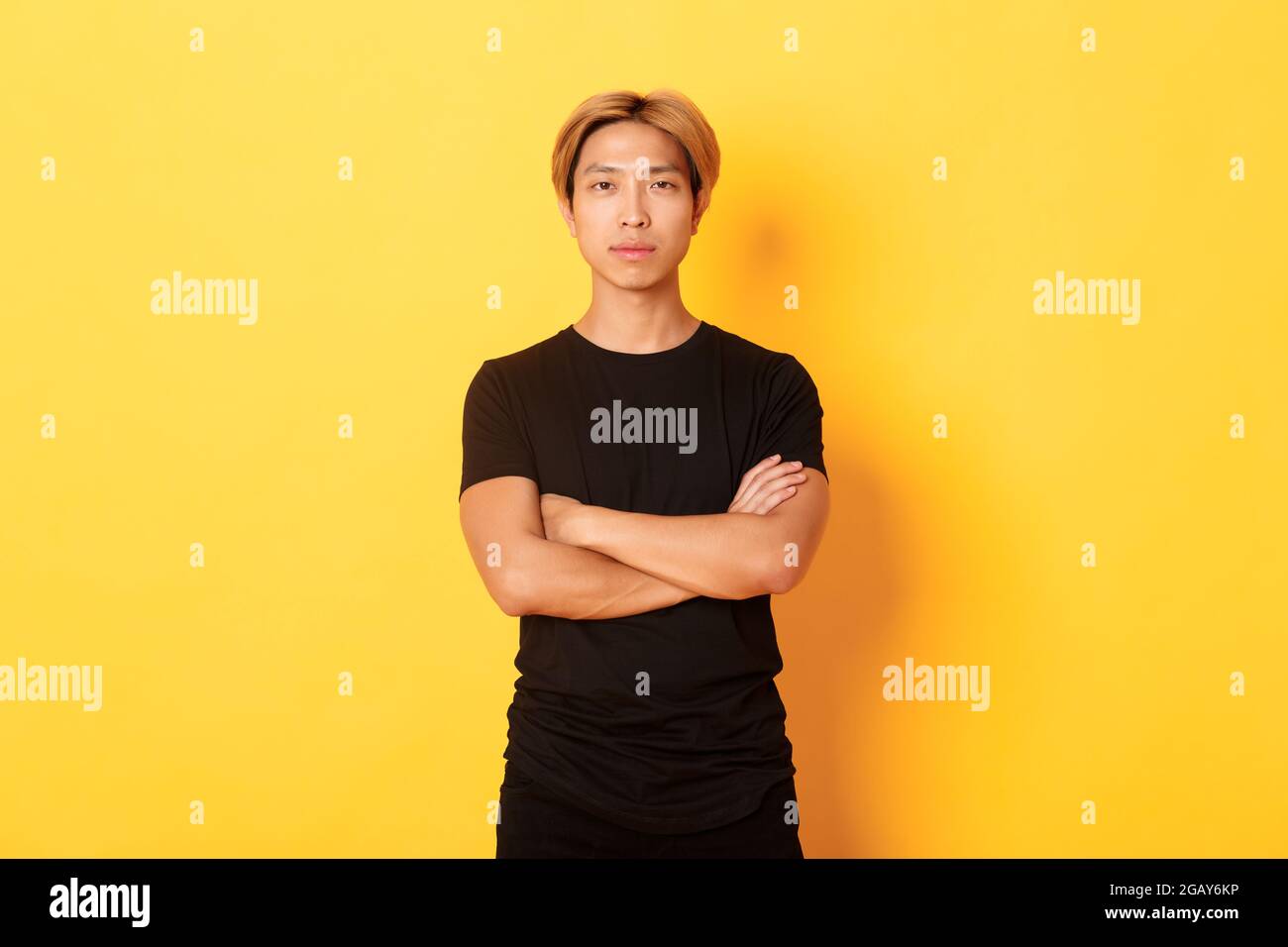 Portrait of serious-looking confident asian guy in black t-shirt, cross ...