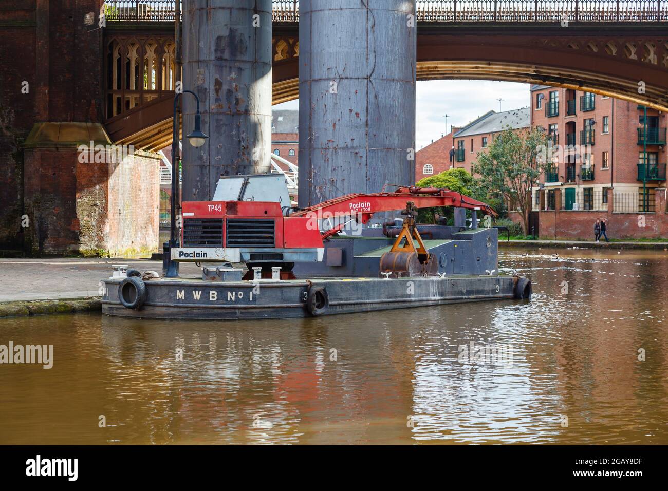 Black floating barge with a Poclain TP 45 crane moored by the ...