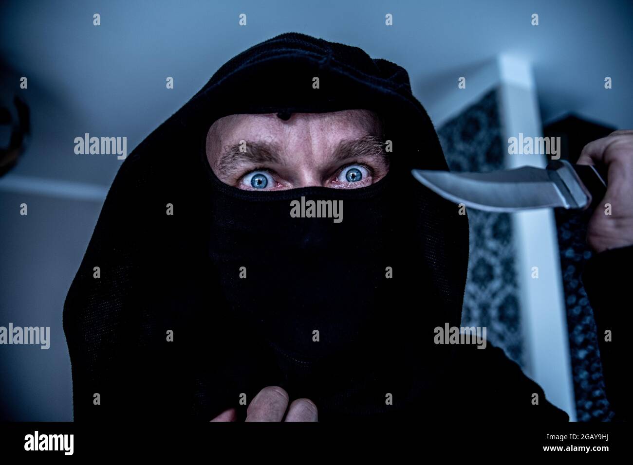 The masked man attacks the victim with a knife Stock Photo - Alamy