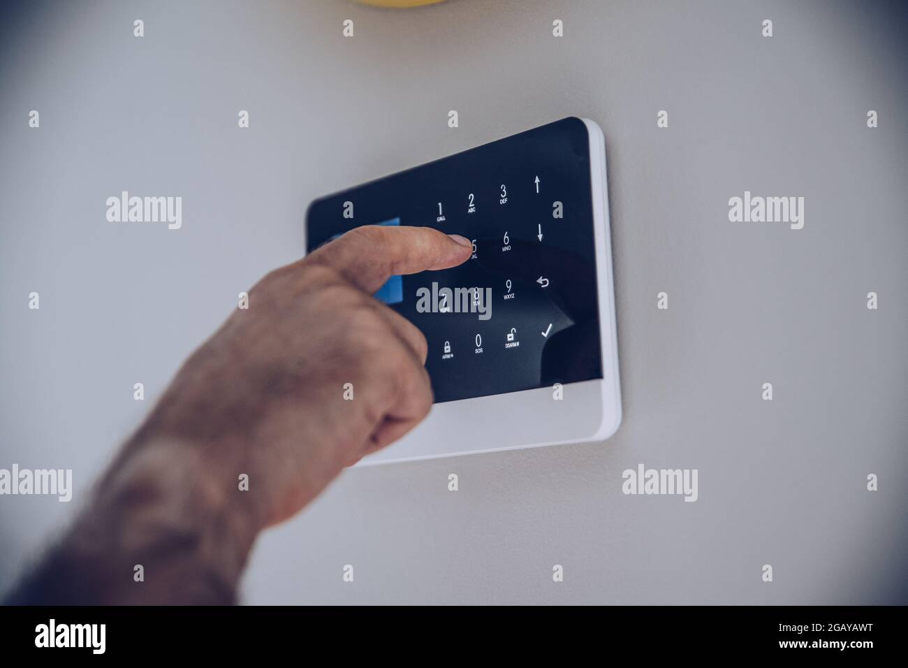 Man entering code pin on home alarm system keypad Stock Photo - Alamy