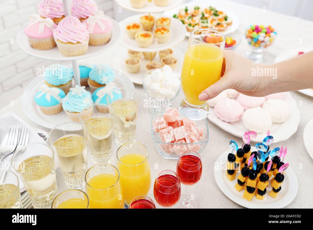 Woman holding glass of juice on buffet background Stock Photo - Alamy