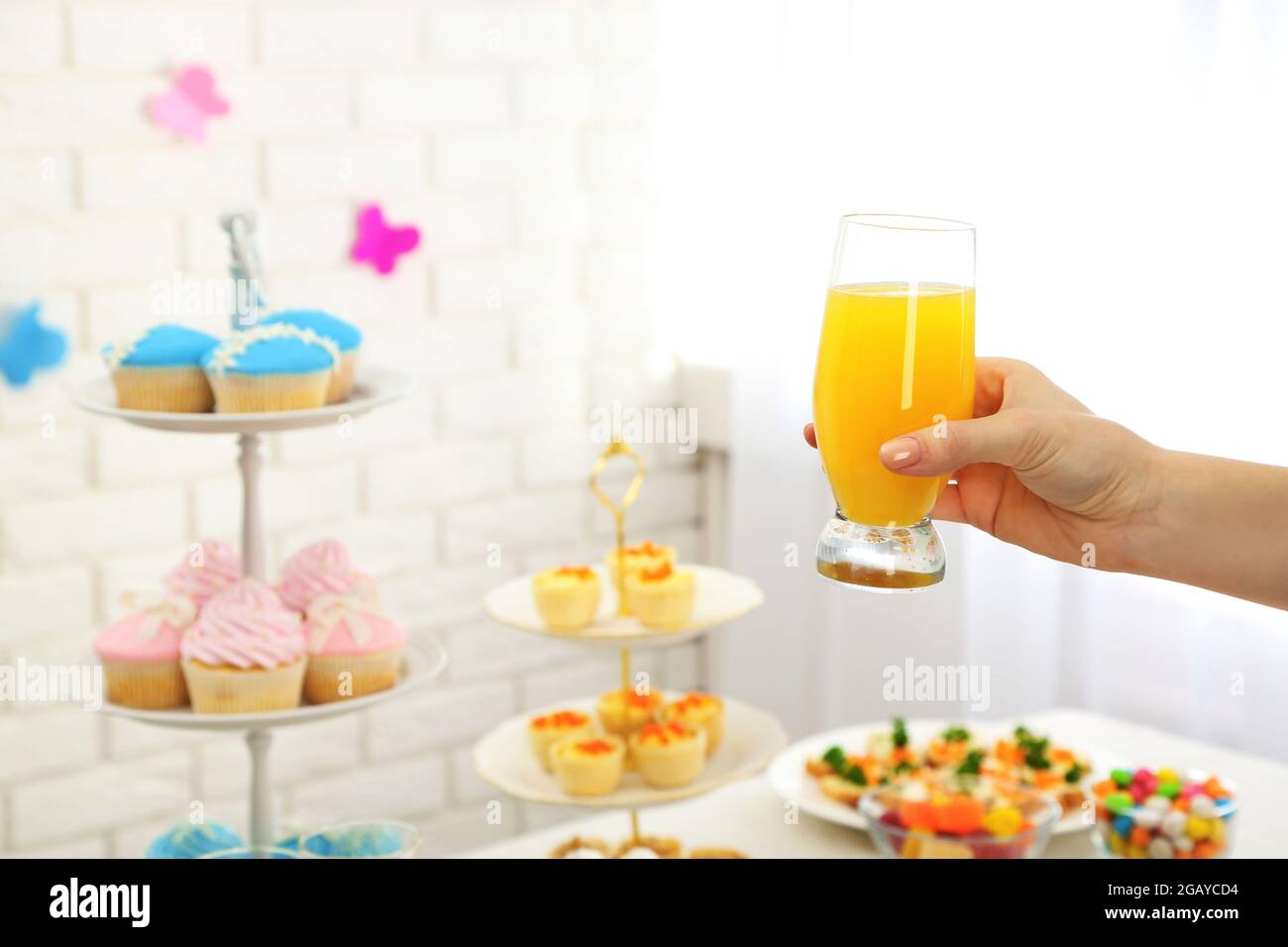 Woman holding glass of juice on buffet background Stock Photo - Alamy