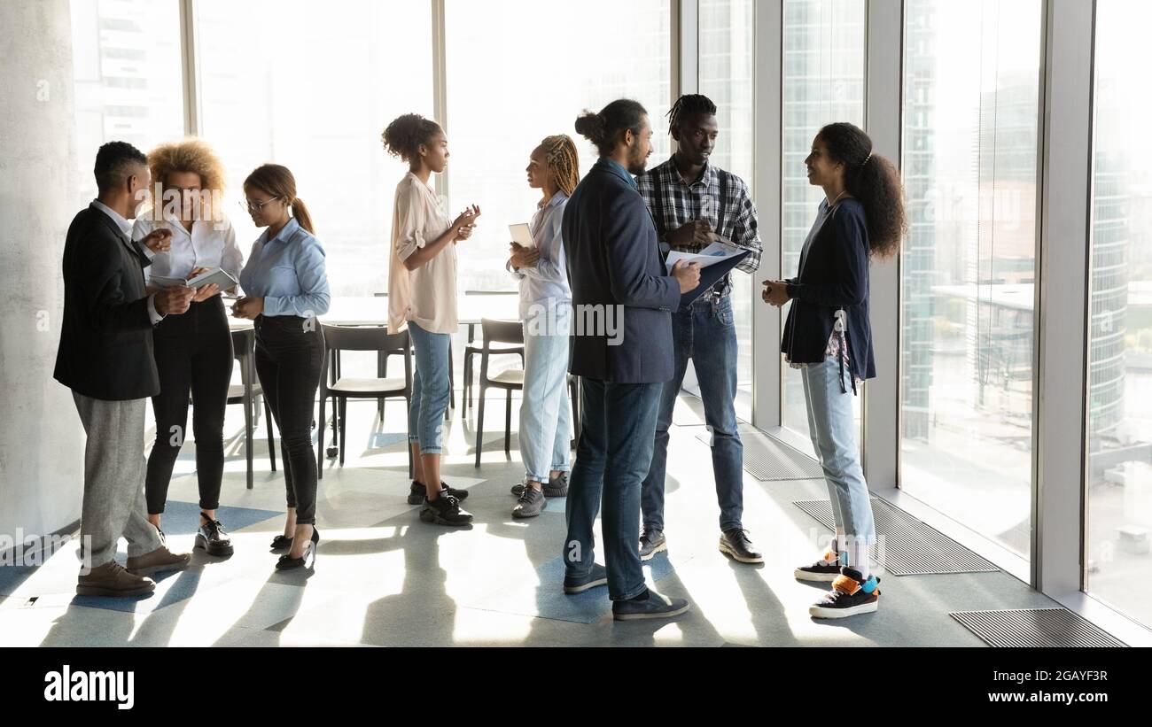 Motivated african american colleagues talking in small groups Stock ...