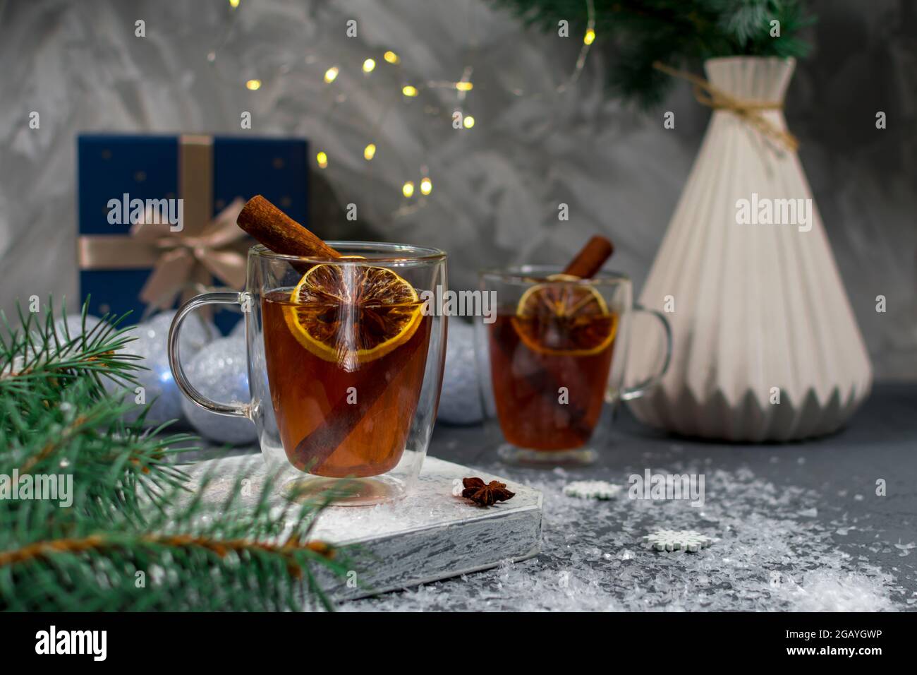 Christmas card. Two glass cups of tea with lemon and cinnamon sticks ...