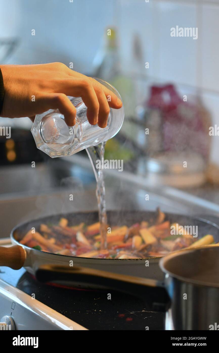 Photo of food being cooked in kitchen, frying vegetables in pan and ...