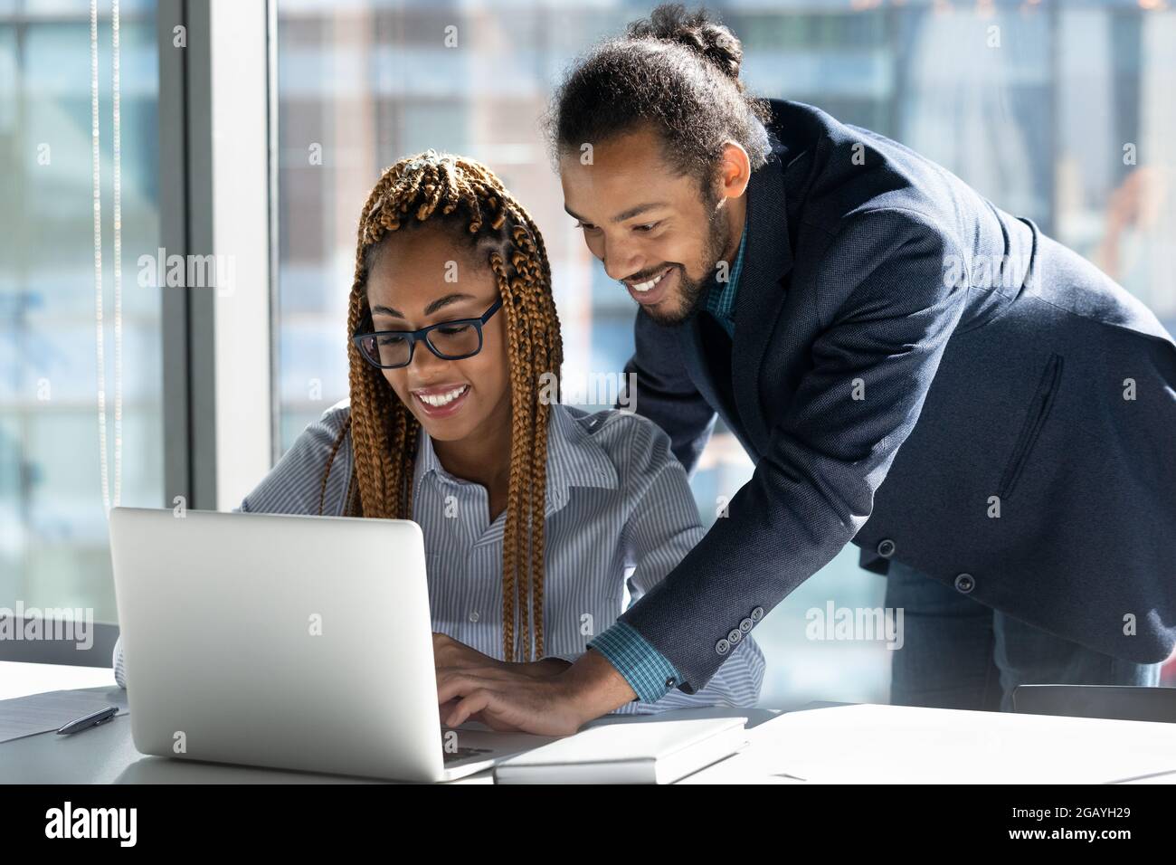 Happy skilled young male african leader helping colleague Stock Photo ...