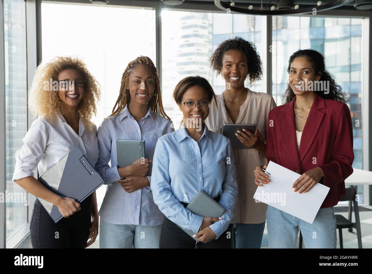 Happy corporate african american workers posing in modern workplace ...