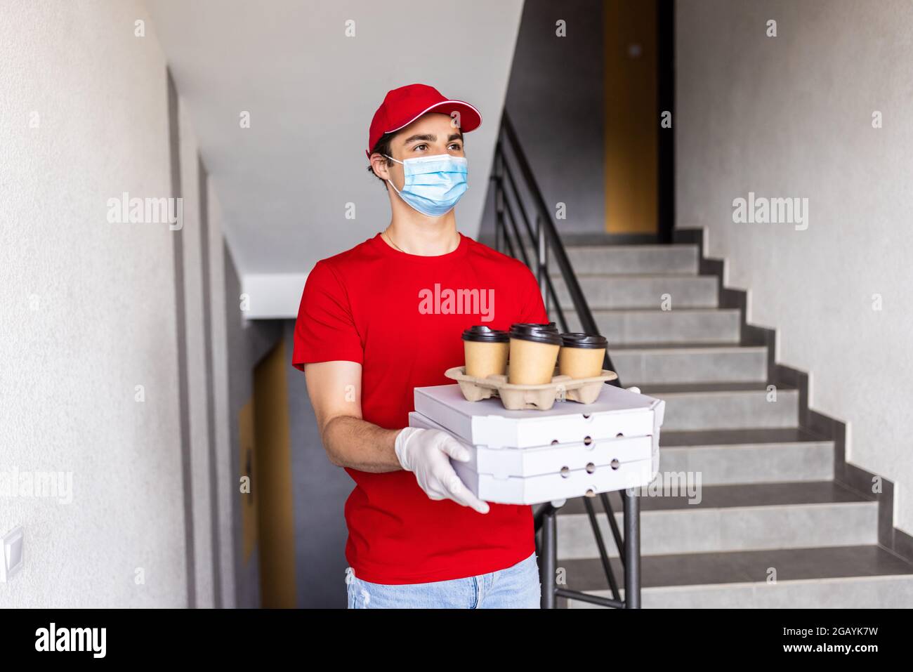 Outdoor portrait of delivery man in uniform with cardboard brown and ...