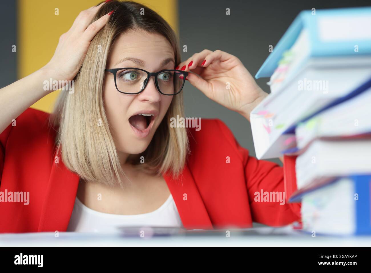 Scared young businesswoman secretary with huge stack of folders Stock ...