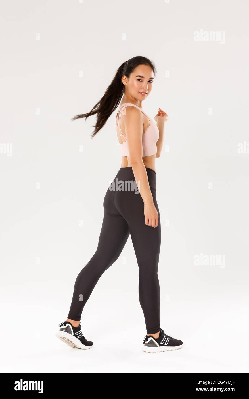 Full length of sassy good-looking, slim asian girl doing fitness ...