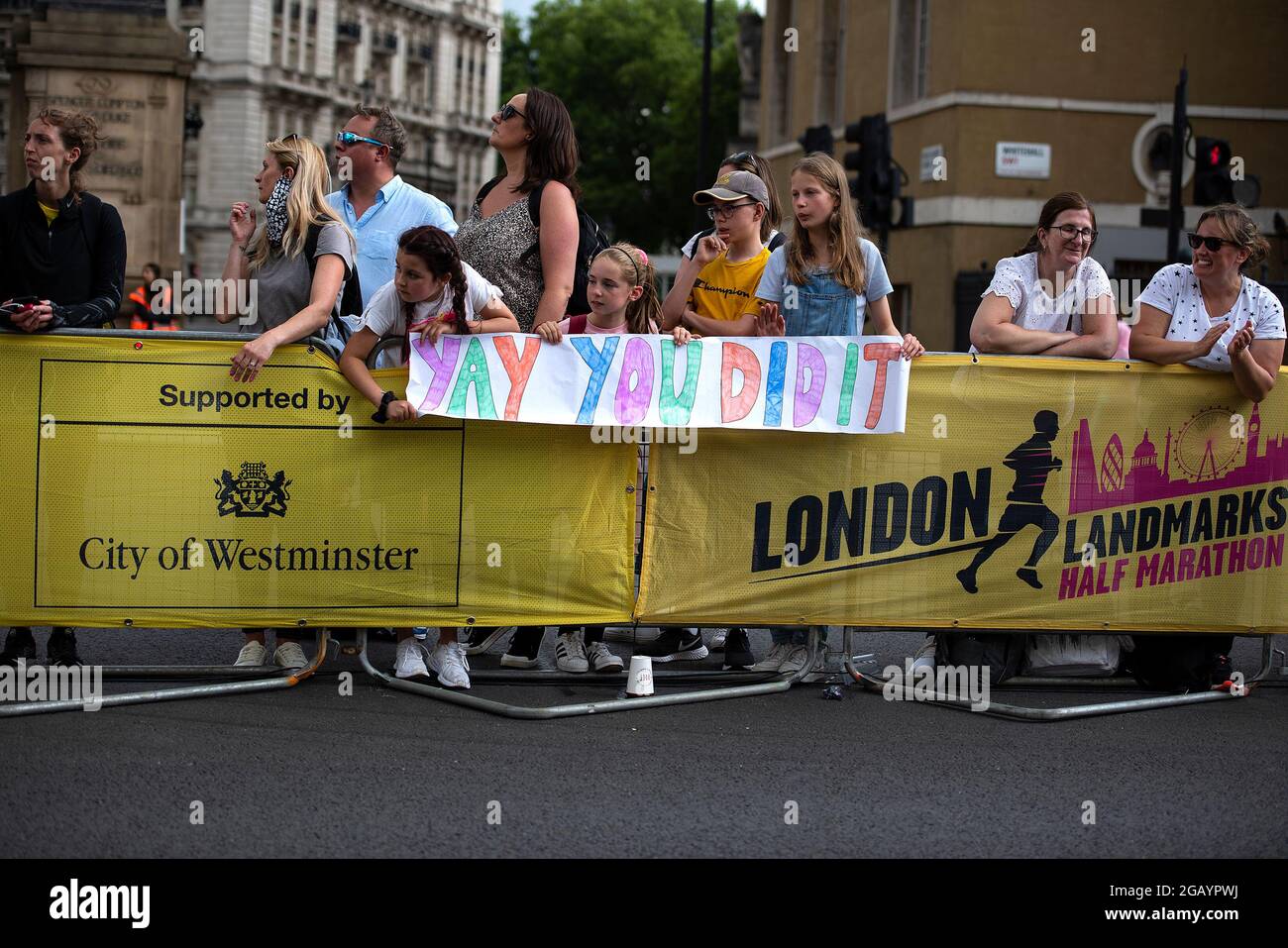 Fans display a sign cheering on runners approaching the finish line ...
