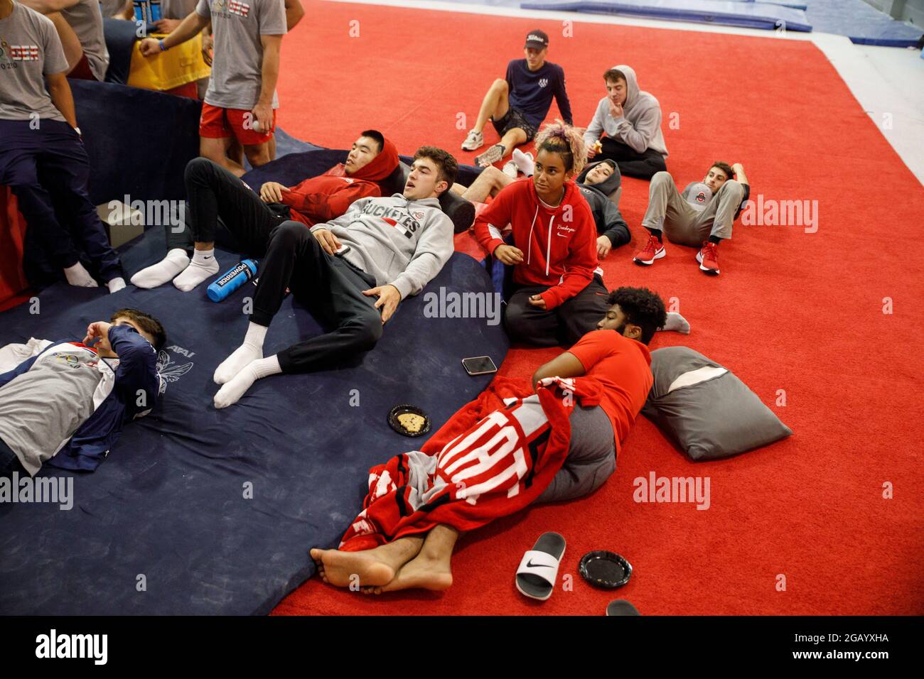 Gymnastics team members lie on the floor as they watch the Men’s Pommel Horse finals at ...