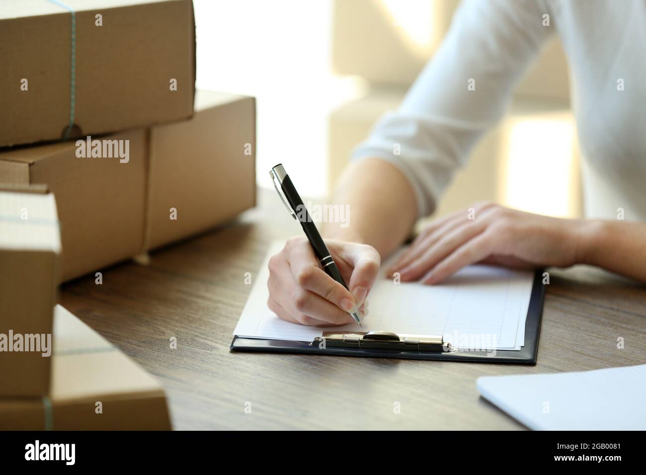 Delivery concept. Woman signs papers among parcels, close up Stock ...