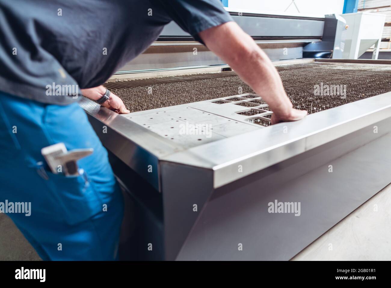 Worker placing work piece on table of jet cutting machine Stock Photo ...