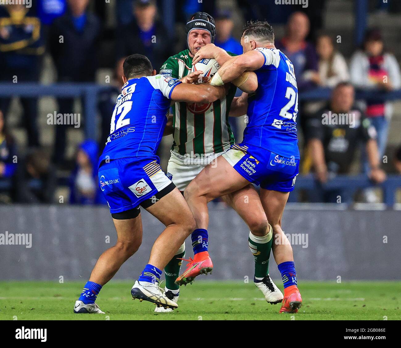 Chris Hill (8) of Warrington Wolves is tackled by James Donaldson (25 ...