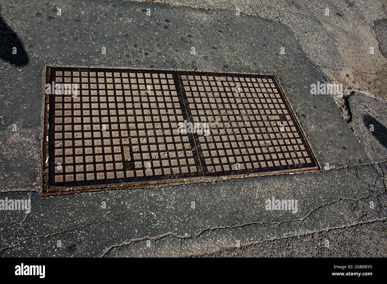 Square hatch for communications on an urban asphalt road. Close-up ...