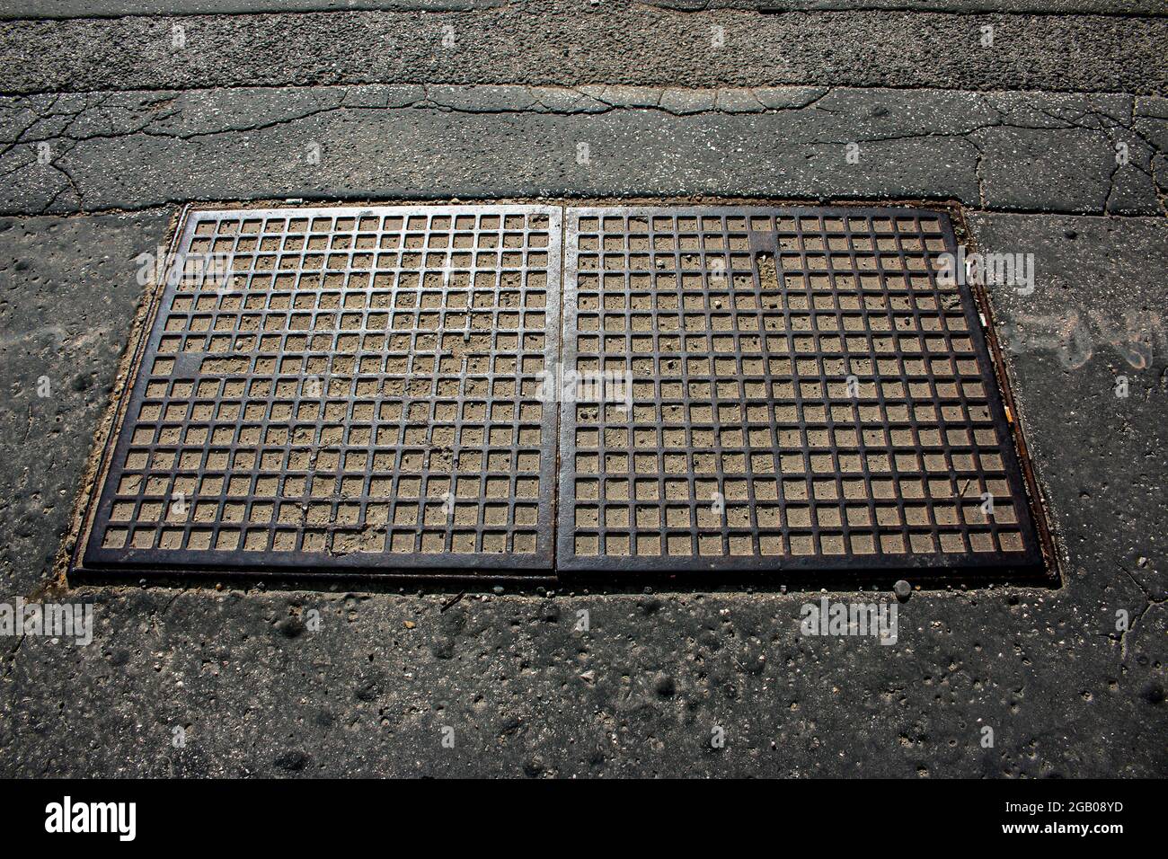 Square hatch for communications on an urban asphalt road. Close-up ...