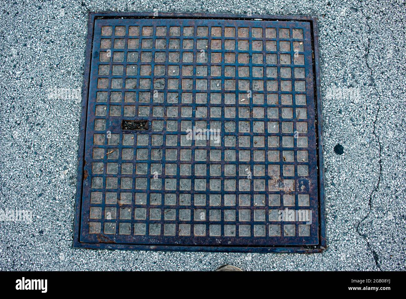 Square hatch for communications on an urban asphalt road. Close-up ...