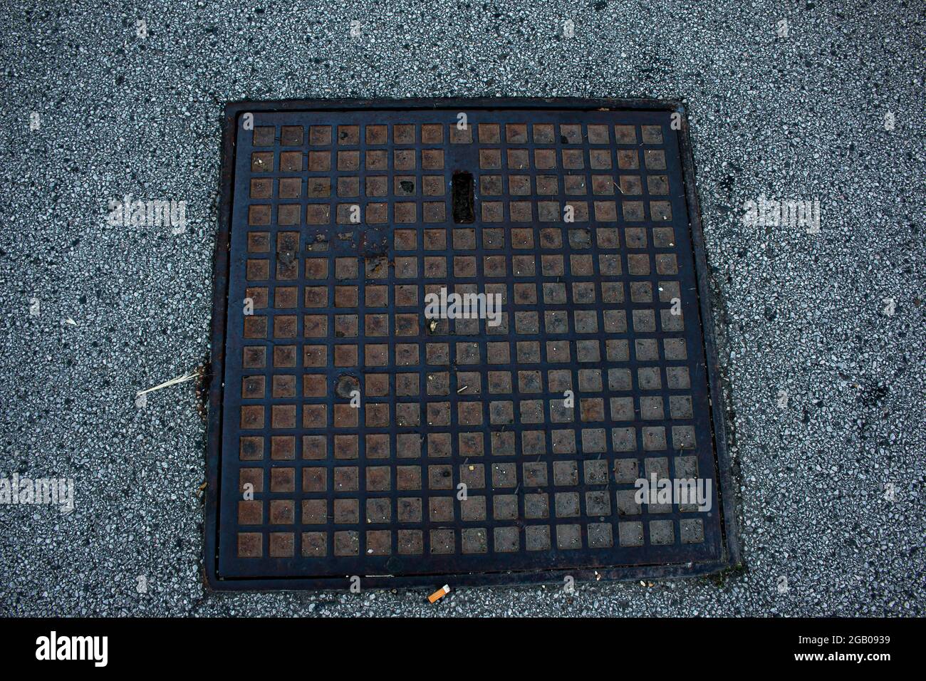 Square hatch for communications on an urban asphalt road. Close-up ...