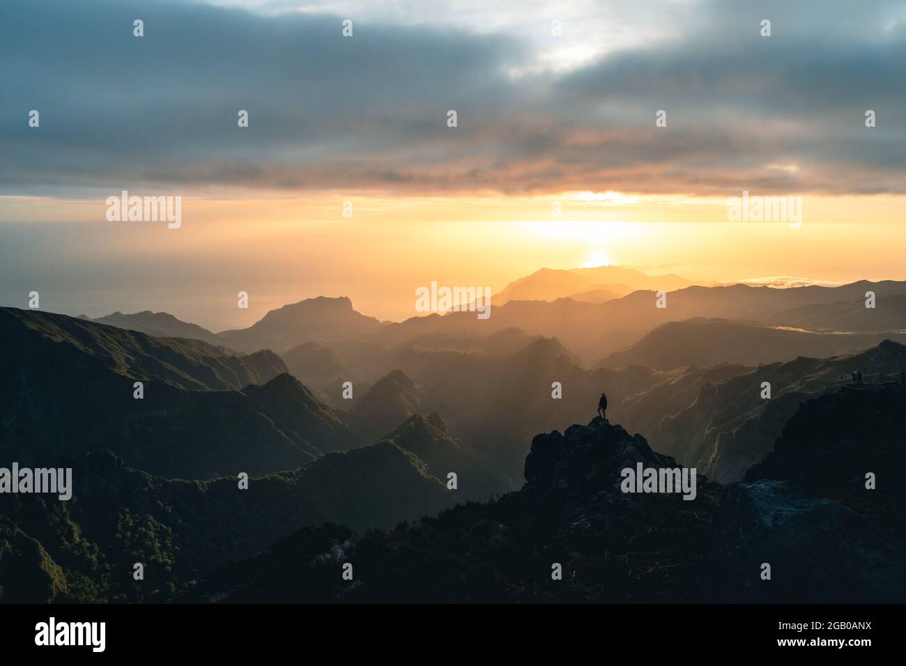 Man stands alone on the peak of rock during sunrise at Pico do Arieiro ... Man stands alone on the peak of rock during sunrise at Pico do Arieiro ...
