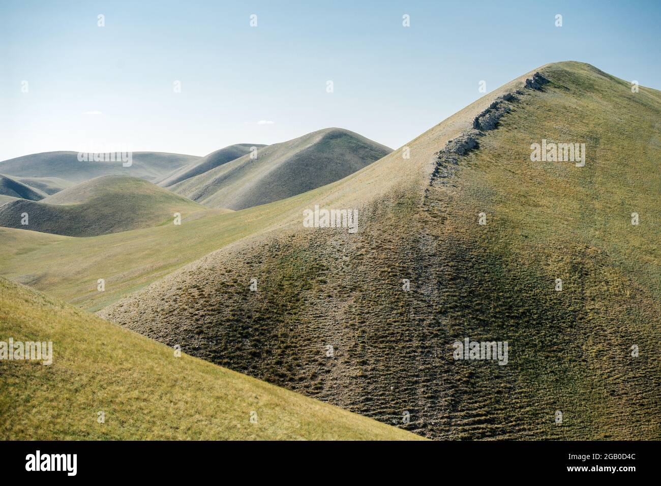 Smooth beautiful grassy hill ridge going all the way to the distance ...