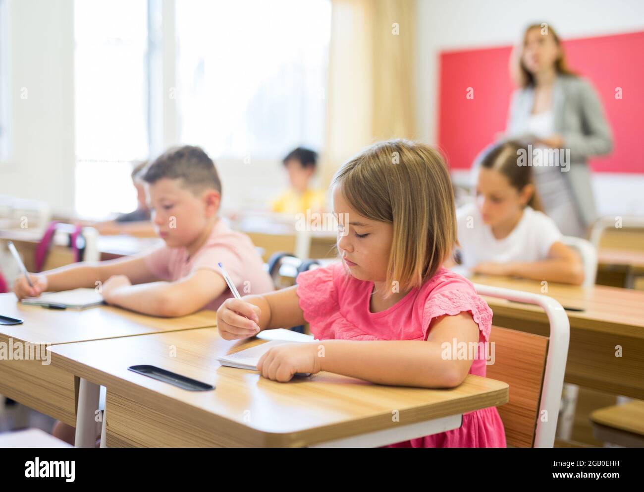 Schoolgirl sitting in classroom during lesson in elementary school ...