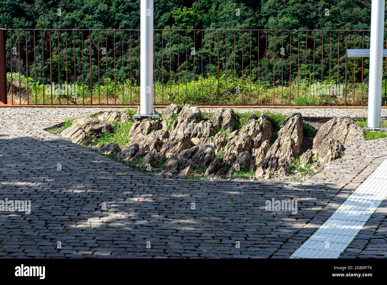 A pavement made of cobblestones in the center, protruding slate rocks ...