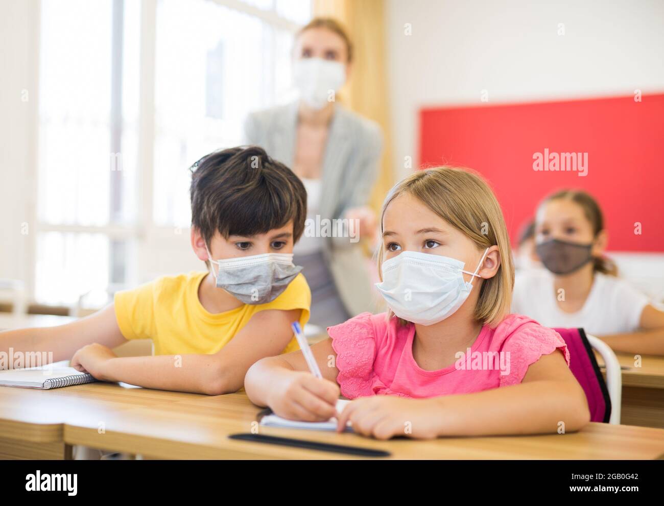 Kid in mask cheating during test Stock Photo - Alamy