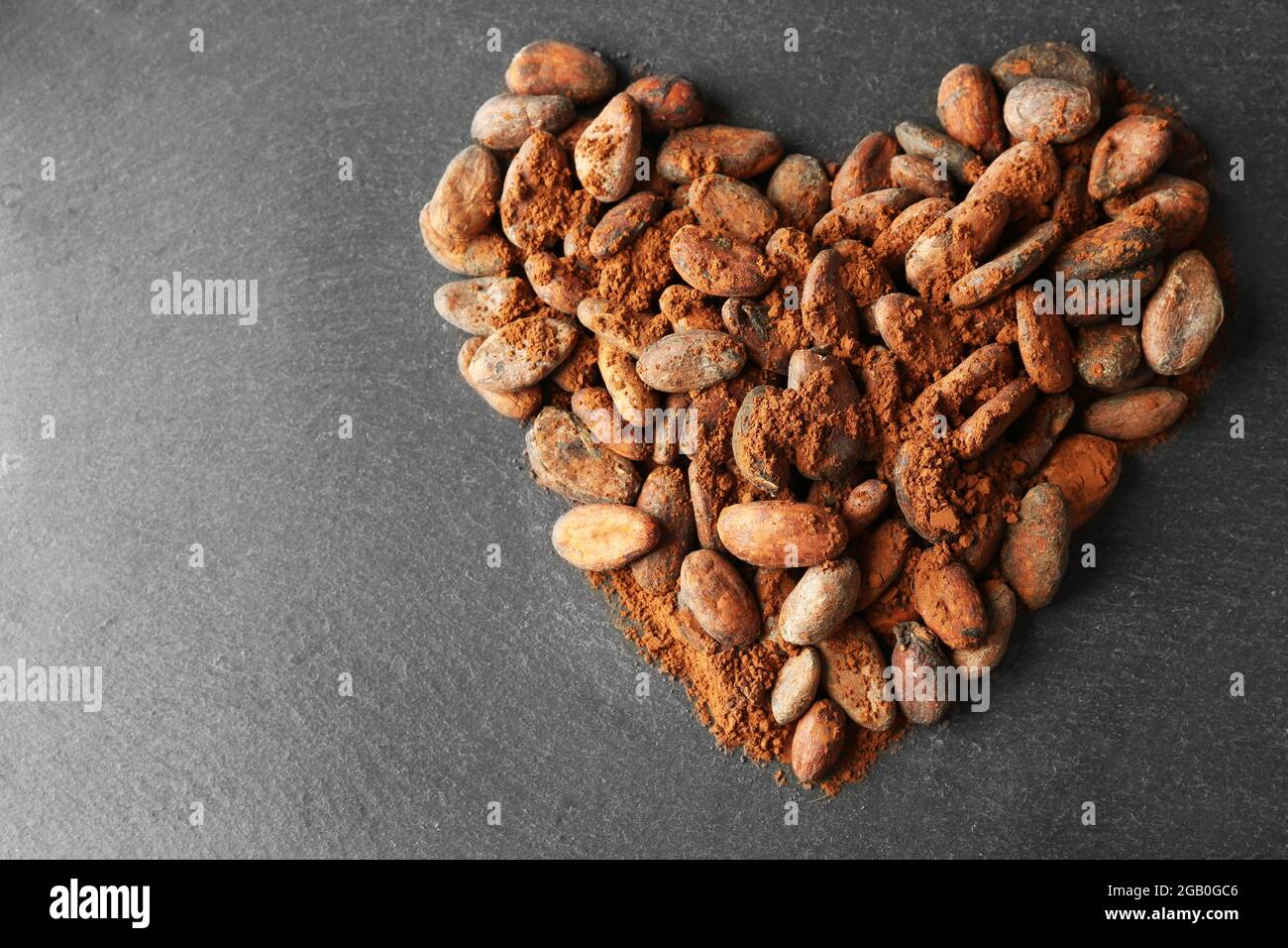 Heart made of aromatic cocoa beans on grey background Stock Photo - Alamy