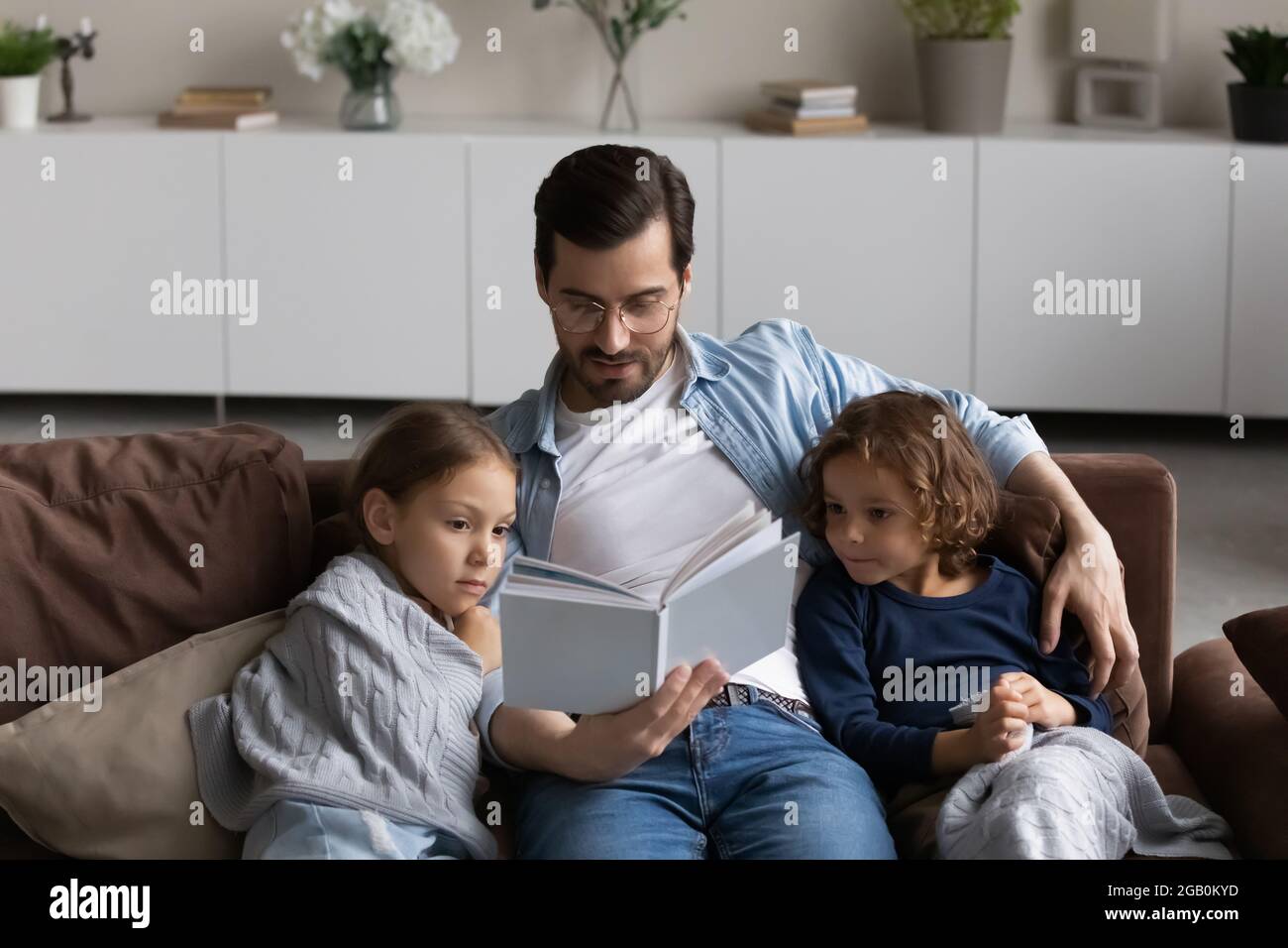 Young millennial dad entertaining kids at home Stock Photo - Alamy