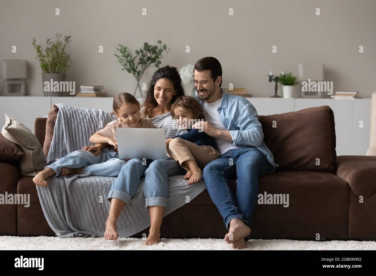 Happy parents and gen Z kids relaxing on couch Stock Photo - Alamy