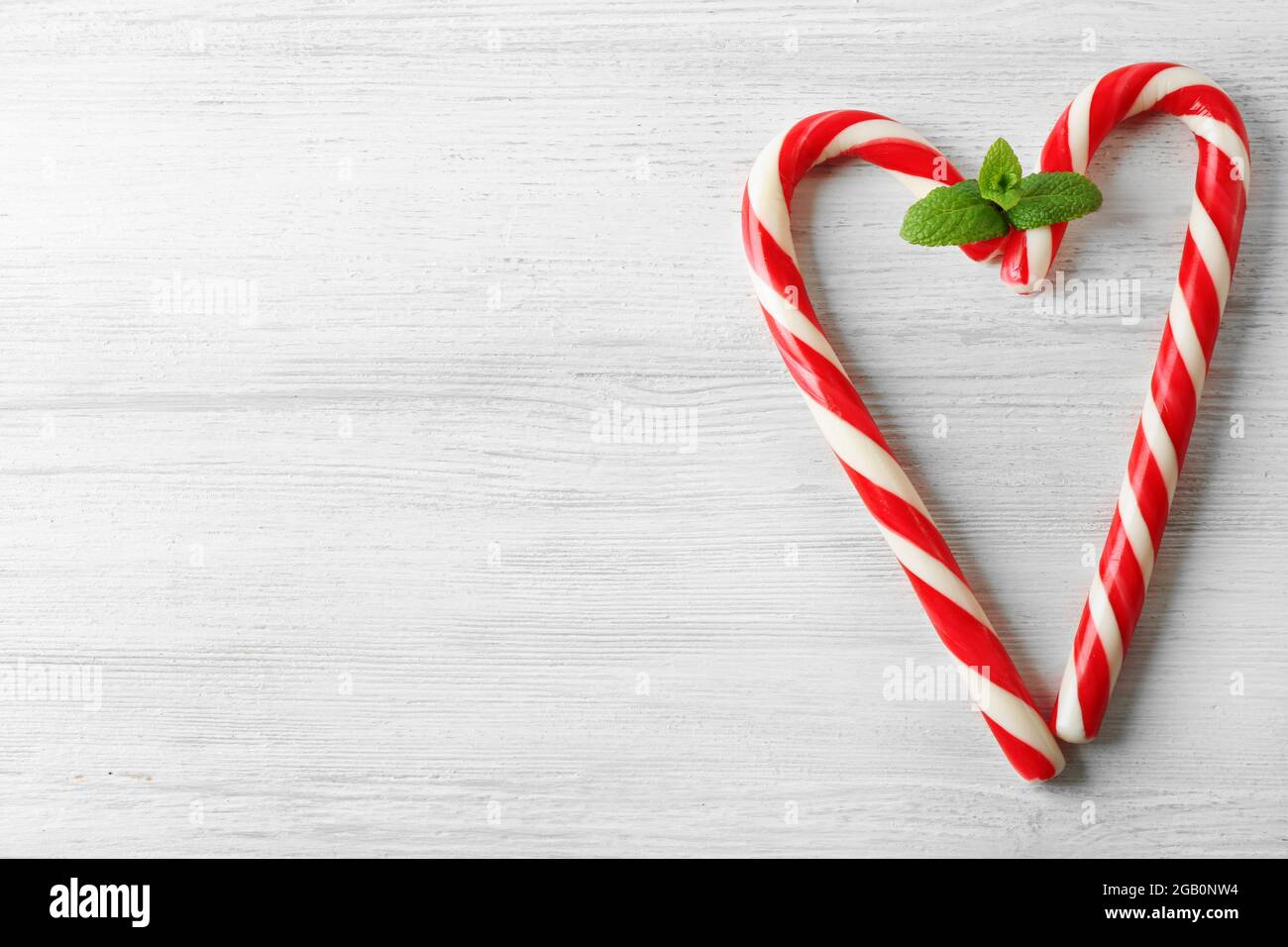 Lollipop candies like heart with mint on light background Stock Photo ...