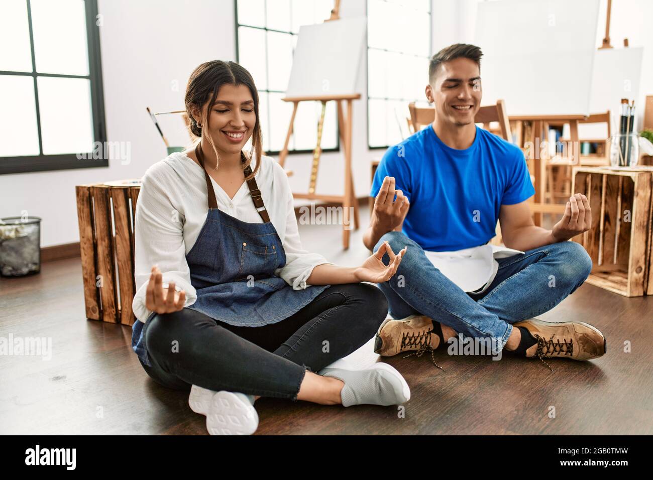 Two students smiling happy sitting on the floor doing yoga pose at art ...