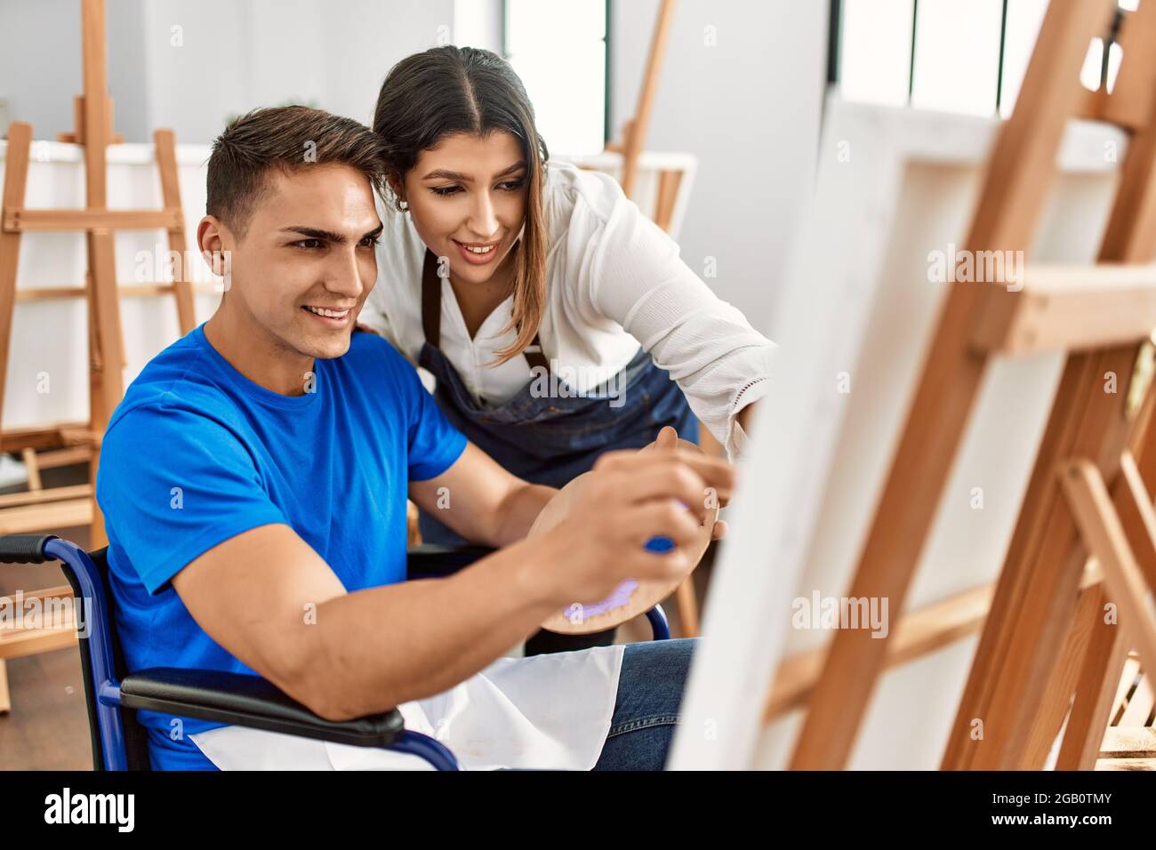 Teacher and disabled paint student sitting on wheelchair smiling happy ...