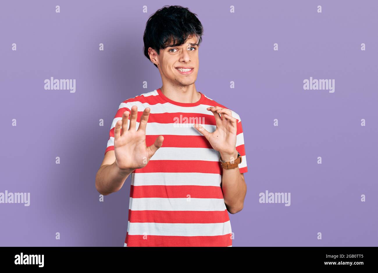 Handsome hipster young man wearing casual striped t shirt disgusted ...
