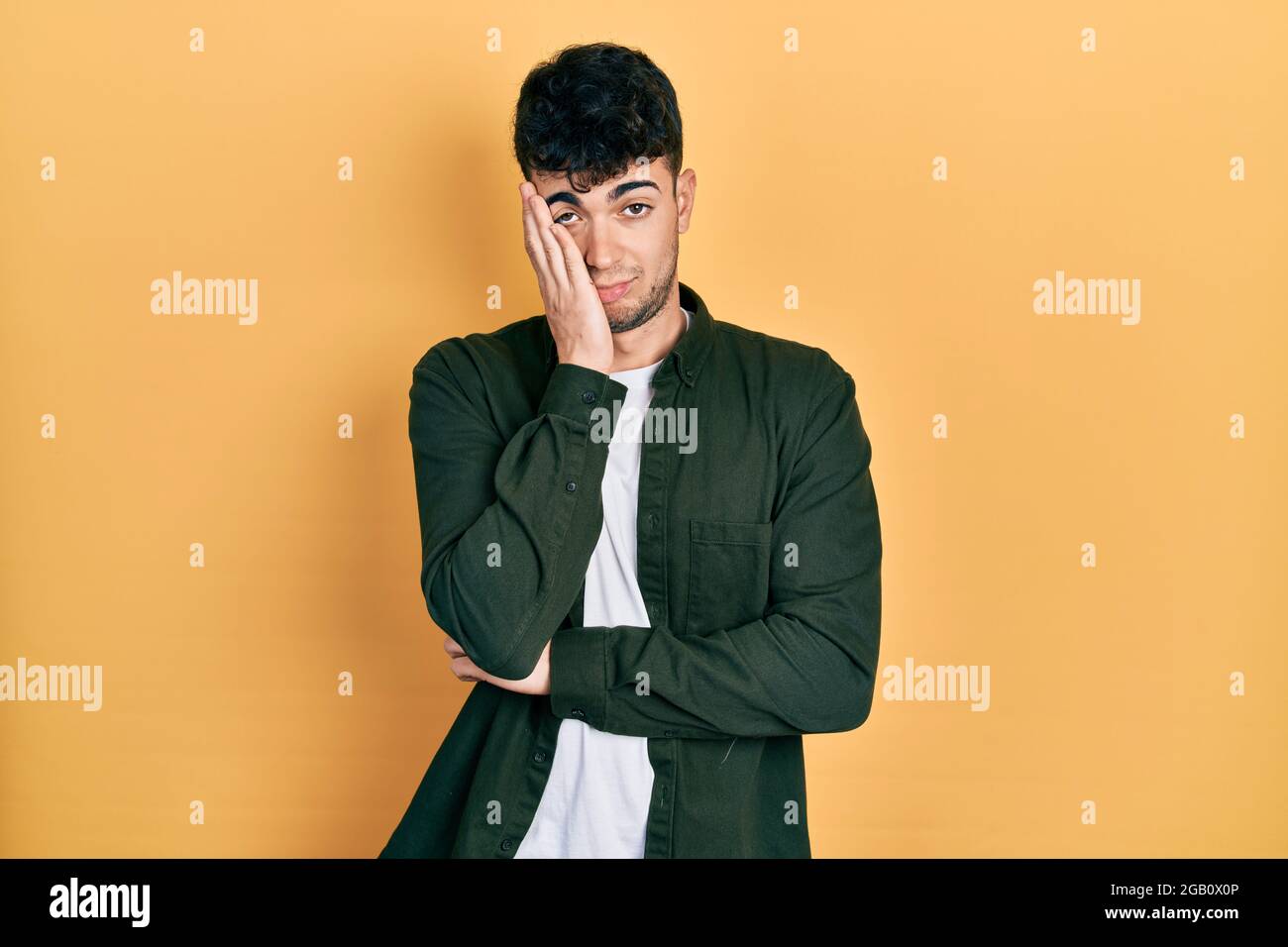 Young hispanic man wearing casual clothes thinking looking tired and ...