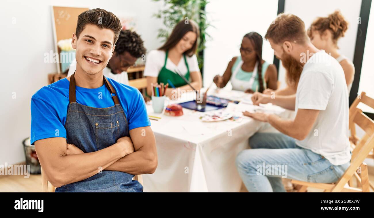Group of people drawing sitting on the table. Hispainc man smiling ...
