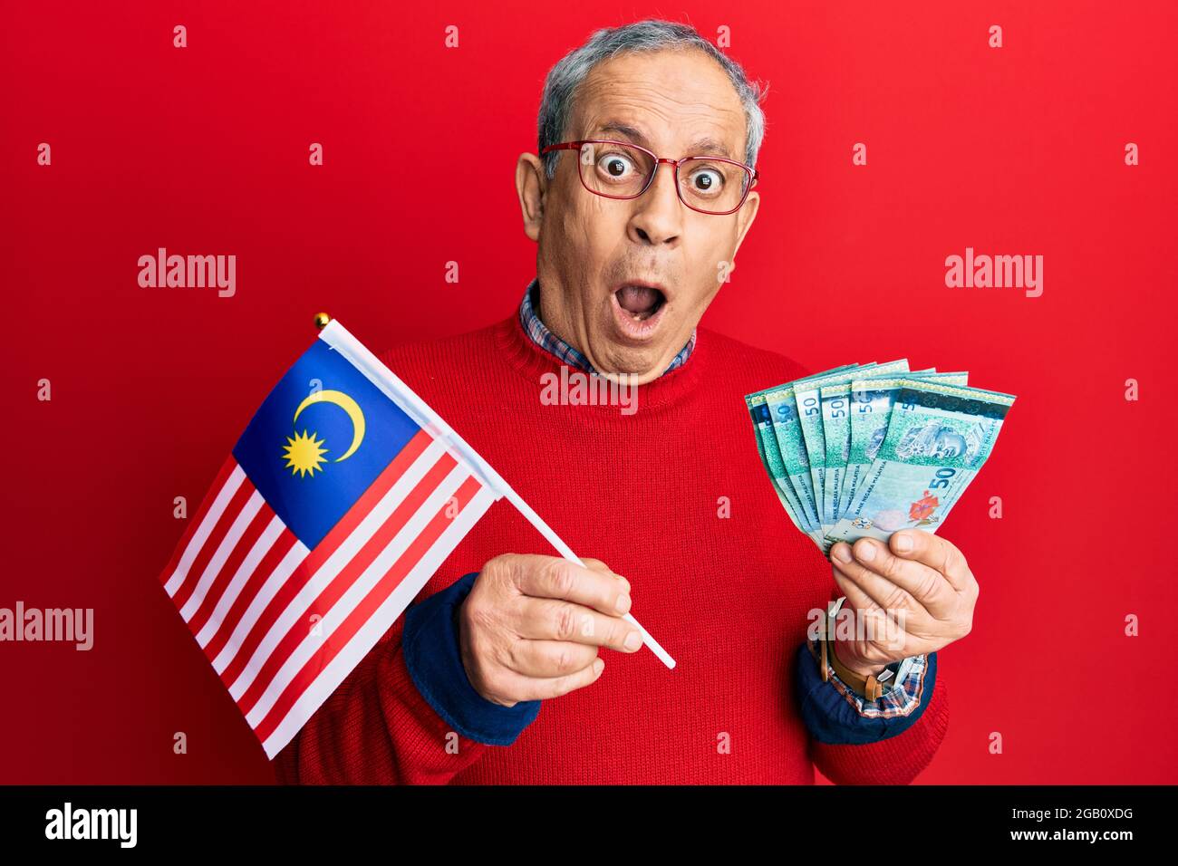 Handsome senior man with grey hair holding malaysia flag and malaysian ...