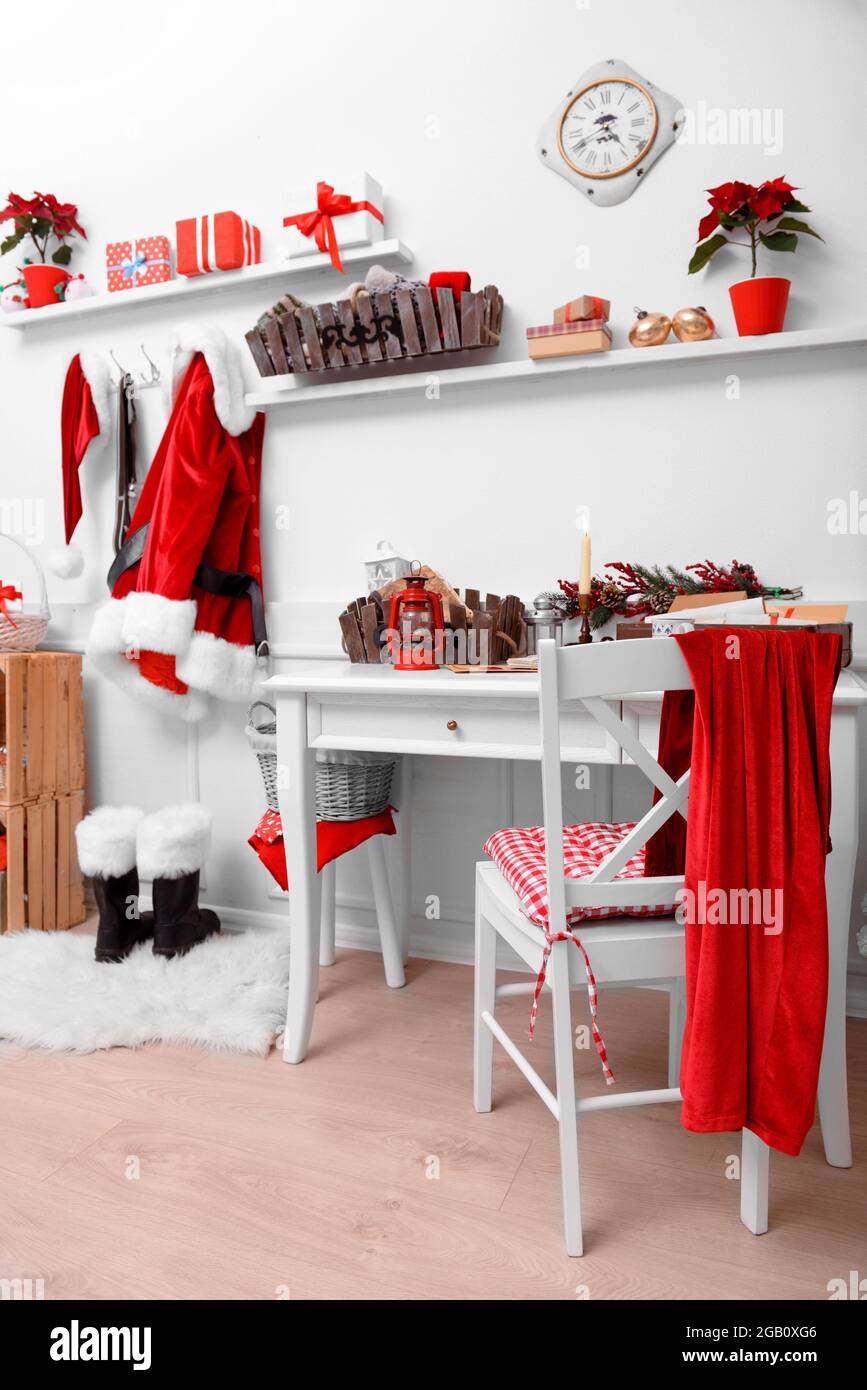 Santa costume hanging in white room Stock Photo - Alamy